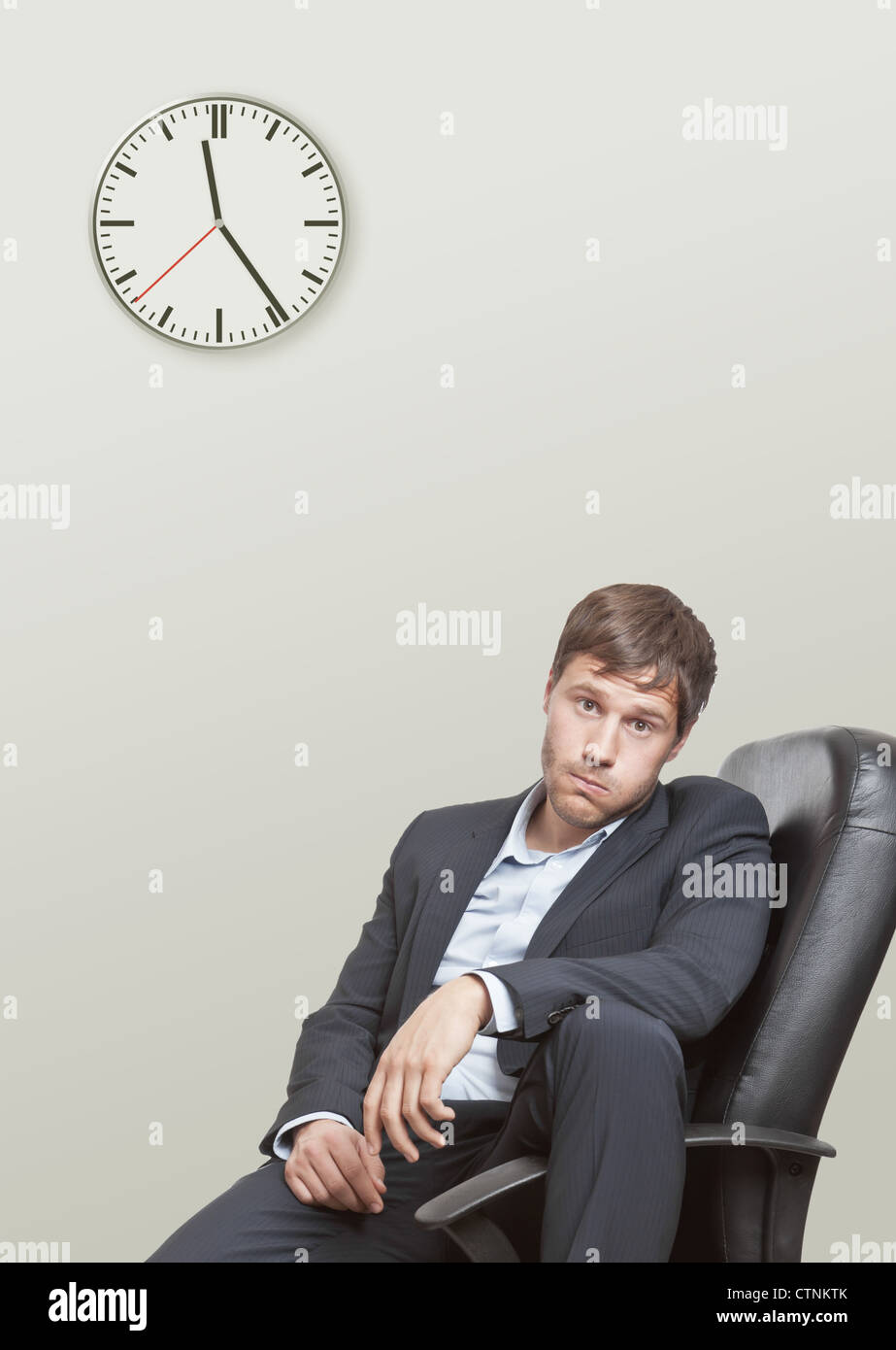 Frustrated young business man waiting for the end of the workday Stock ...