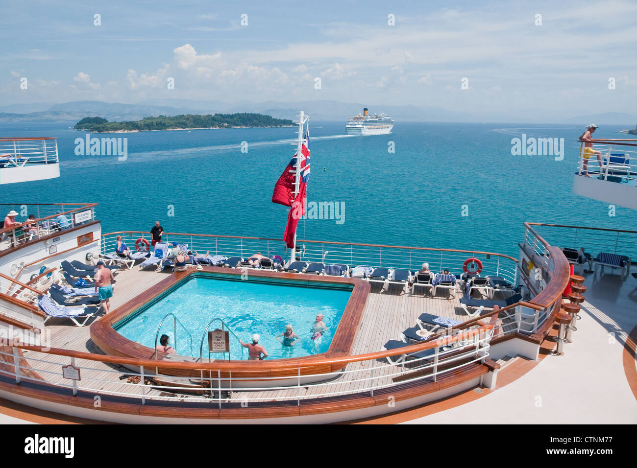 Passengers sunbathing around a pool on board the cruise ship Grand ...