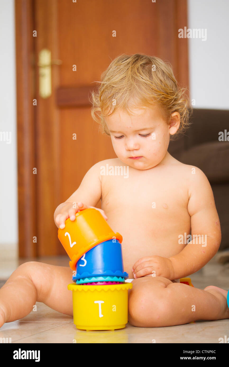 Baby boy playing with his stacking pots Stock Photo - Alamy