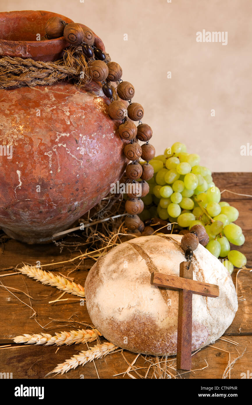 Antique wine jug, cross and rustic loaf of bread as christian symbols ...