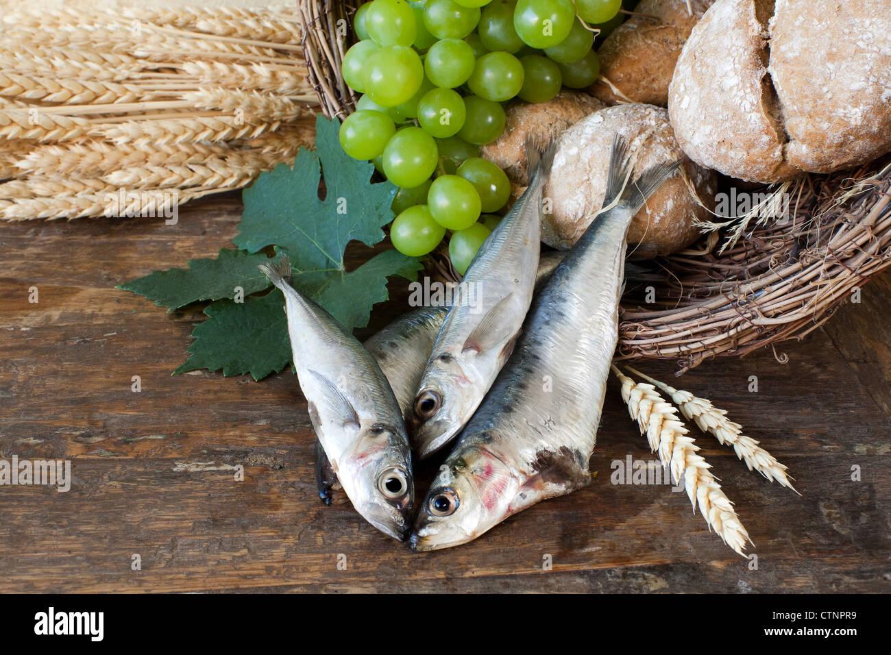 Bread and fish with wine grapes symbolizing the miracles of Jesus ...