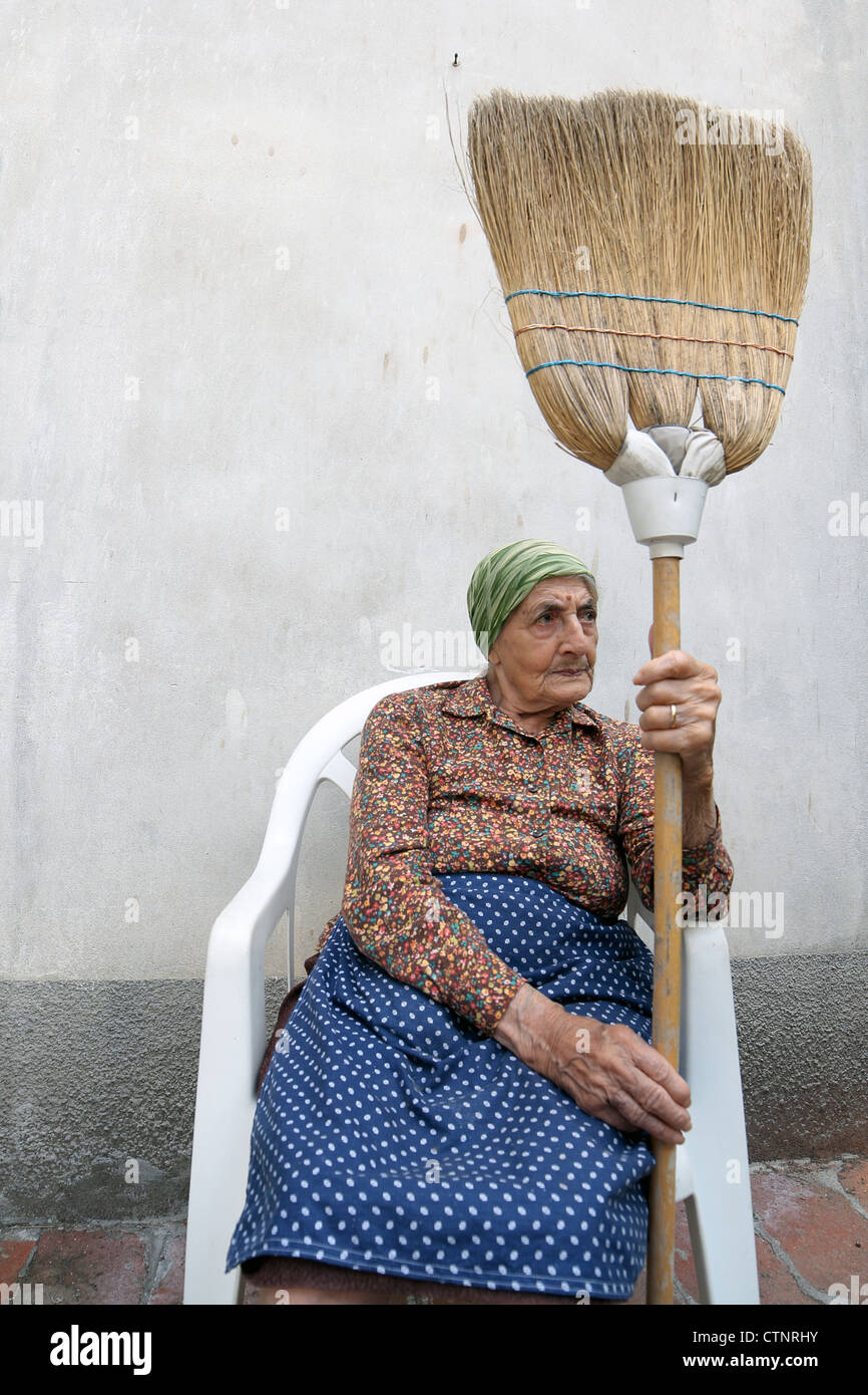 Senior Woman sitting with an old broom Stock Photo - Alamy