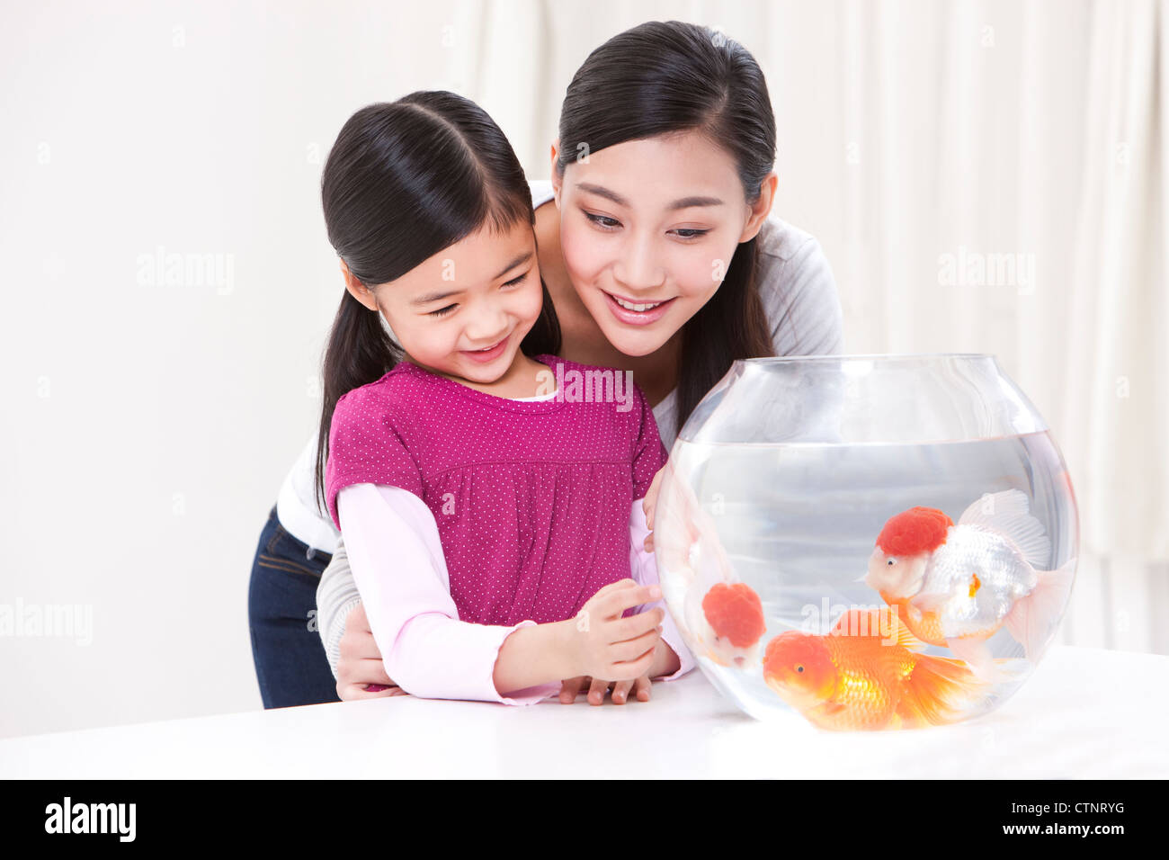 Mother and daughter with goldfish Stock Photo - Alamy