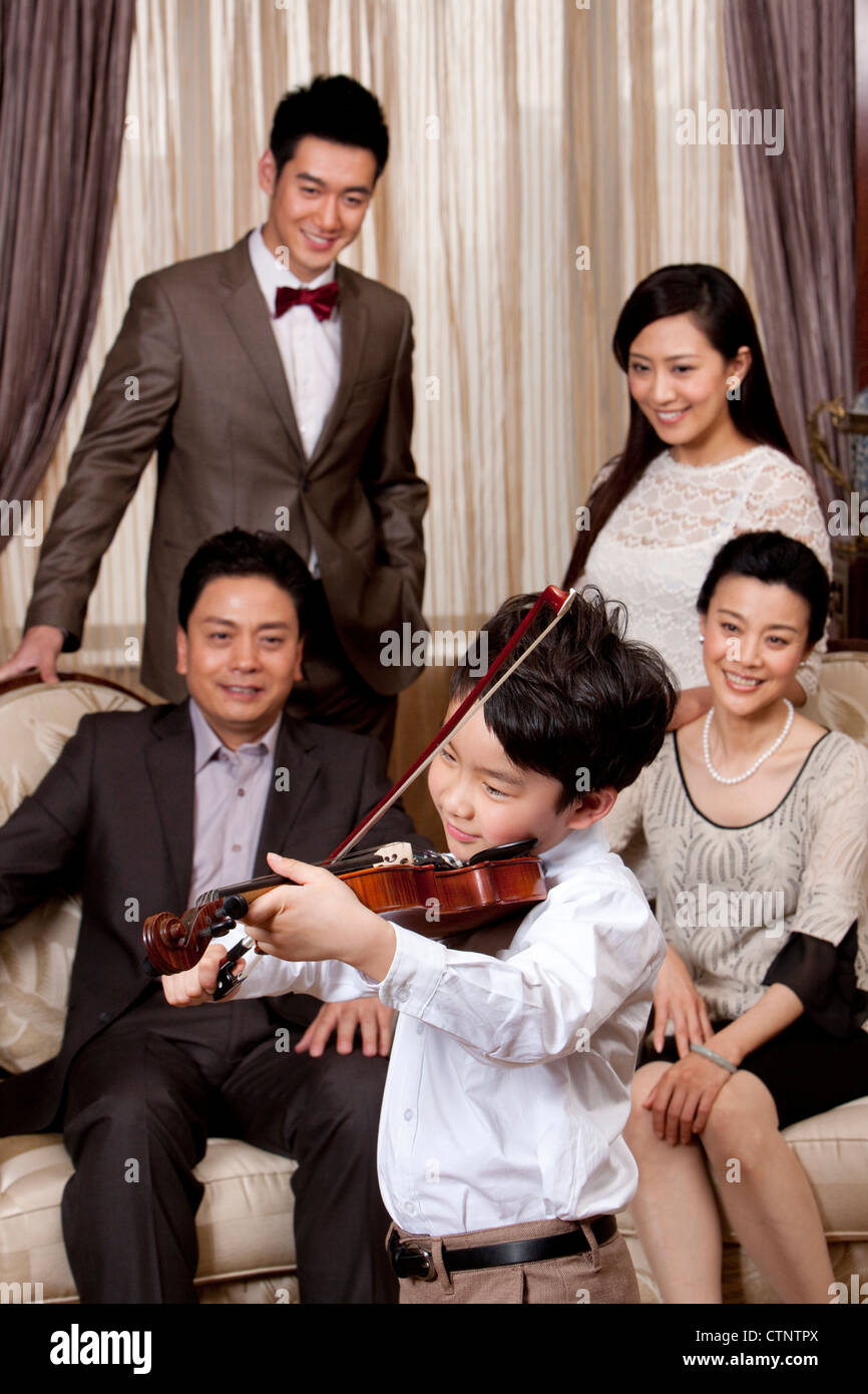 Little boy playing violin in front of family members Stock Photo - Alamy