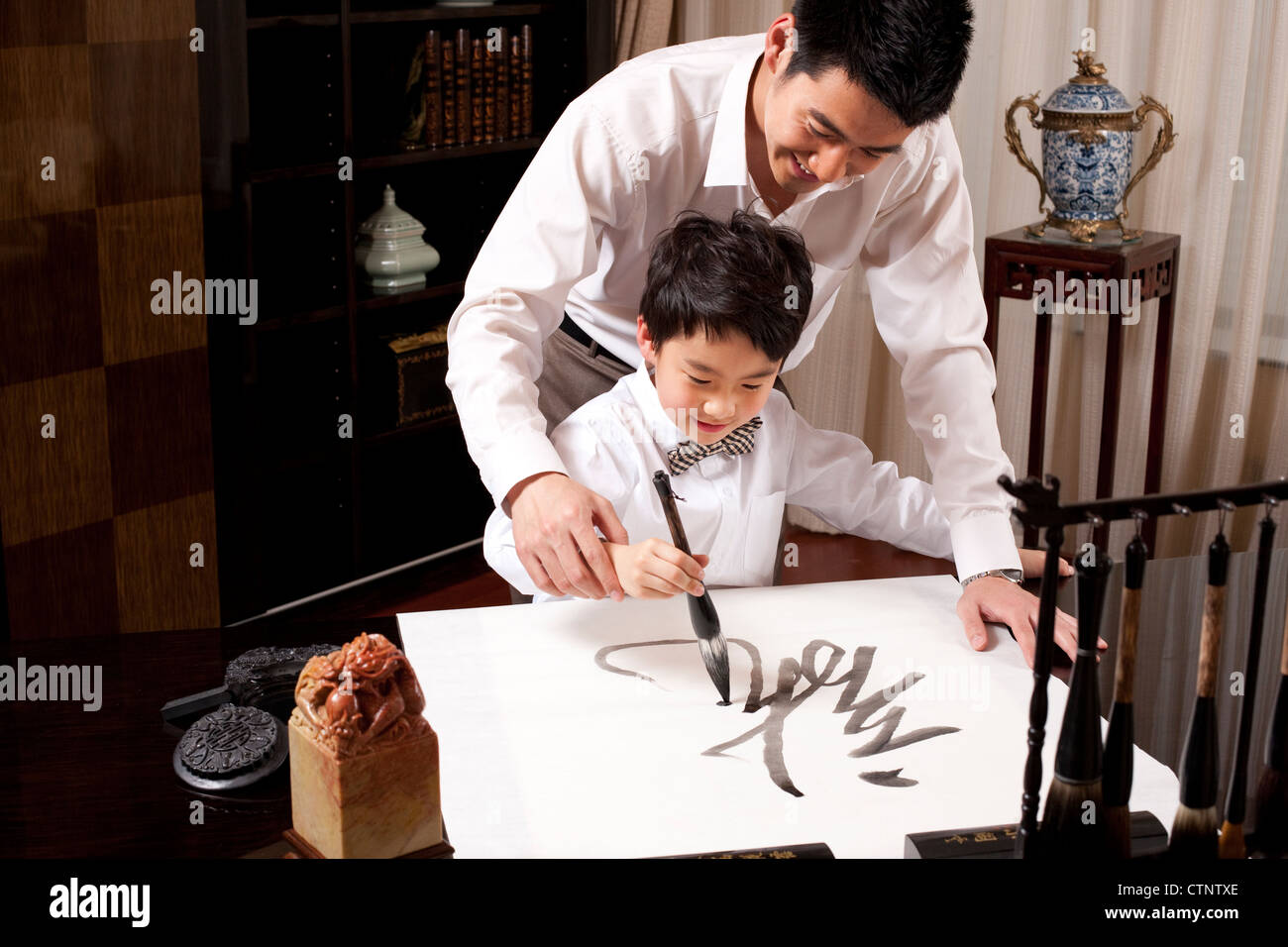 Father and son practising Chinese calligraphy Stock Photo - Alamy