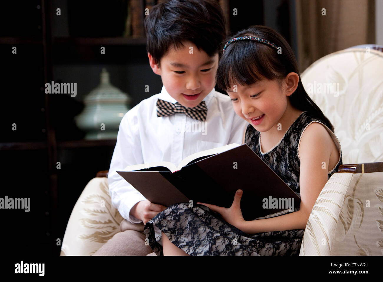 Little boy and girl reading book in study Stock Photo - Alamy