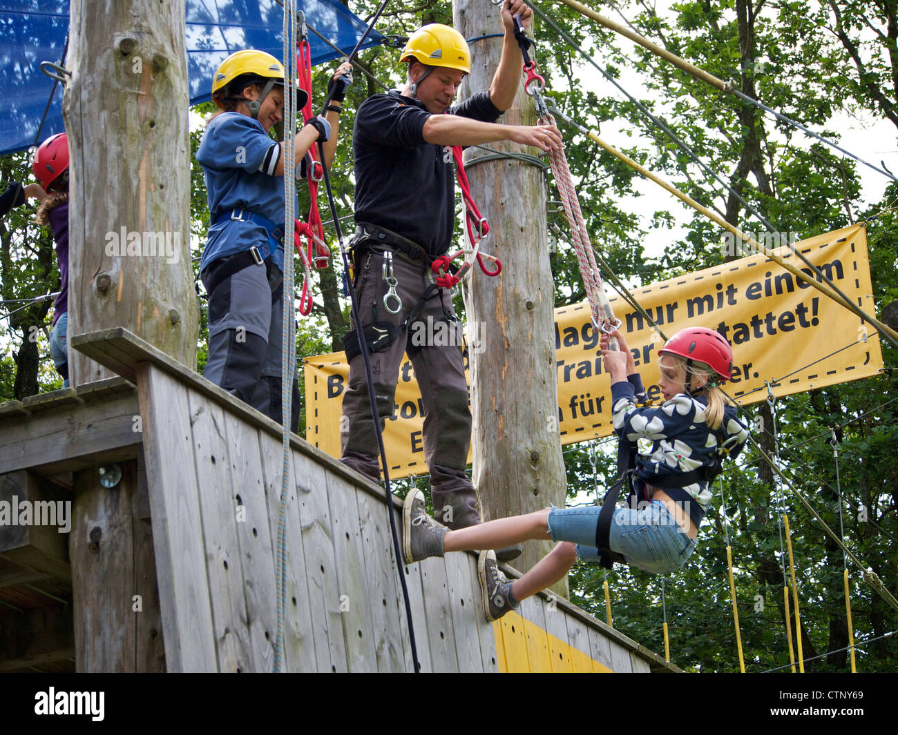 Child learning abseiling technique at climbing school in Heiderscheid ...
