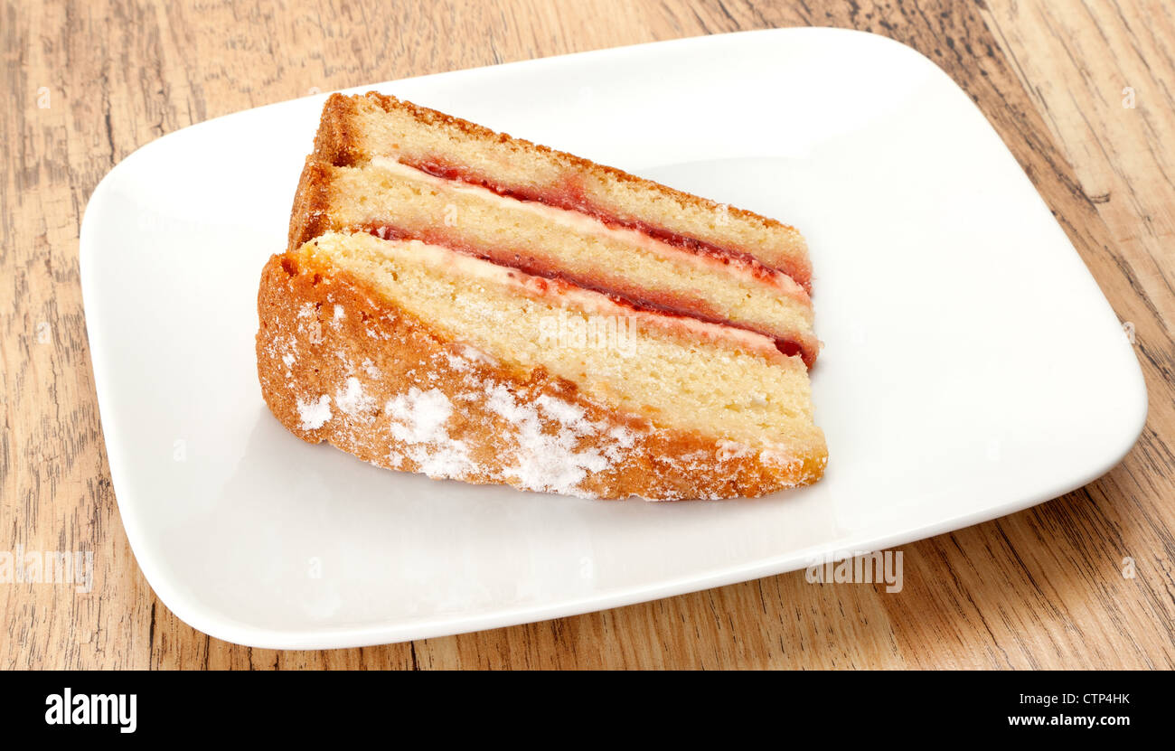 A slice of Victoria sponge cake on a white plate - studio shot with a ...
