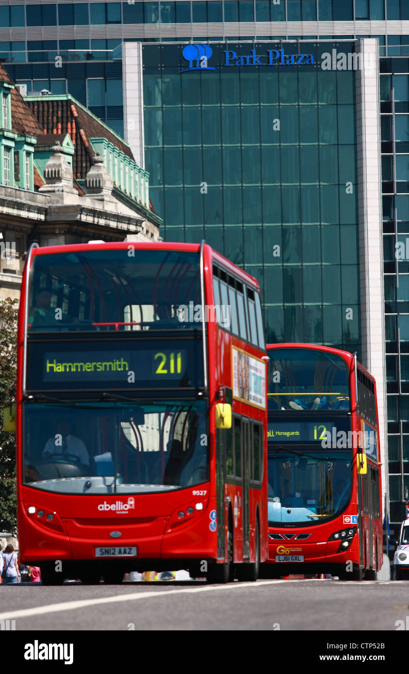 two double decker red London buses traveling on a road in London Stock ...