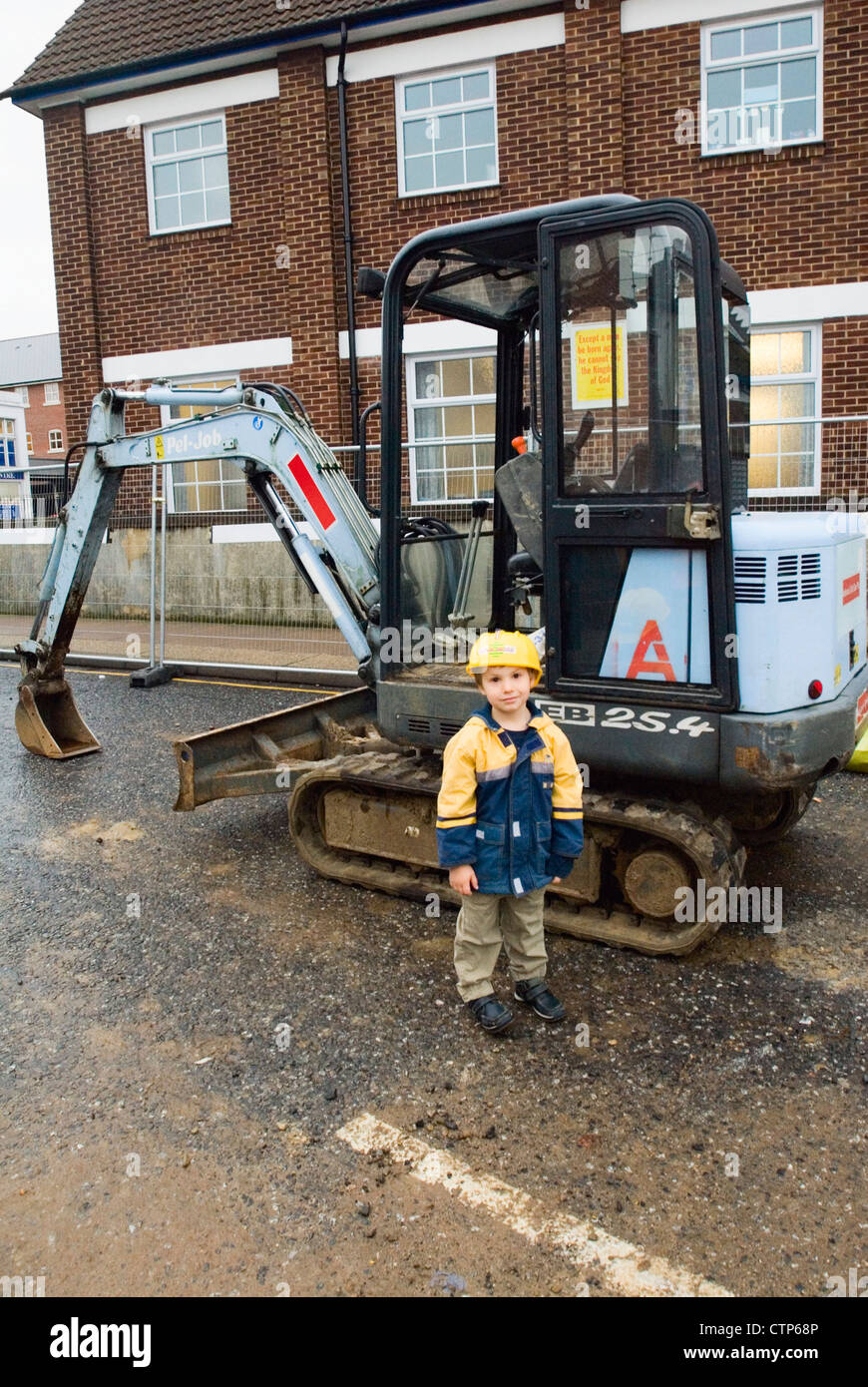 Boy standing near mini digger Stock Photo - Alamy