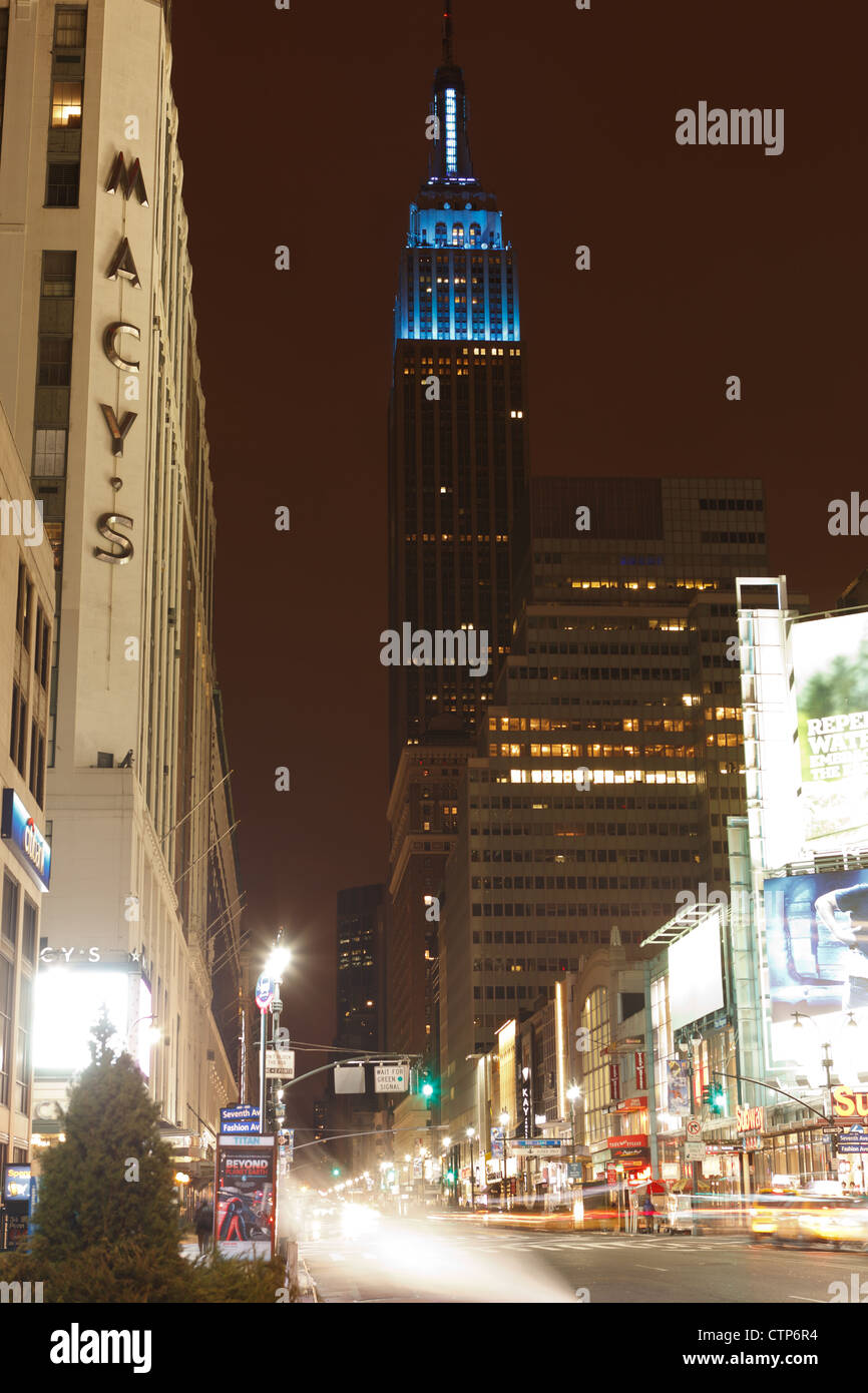 Blue Empire State building and Macy's department store at night Stock ...