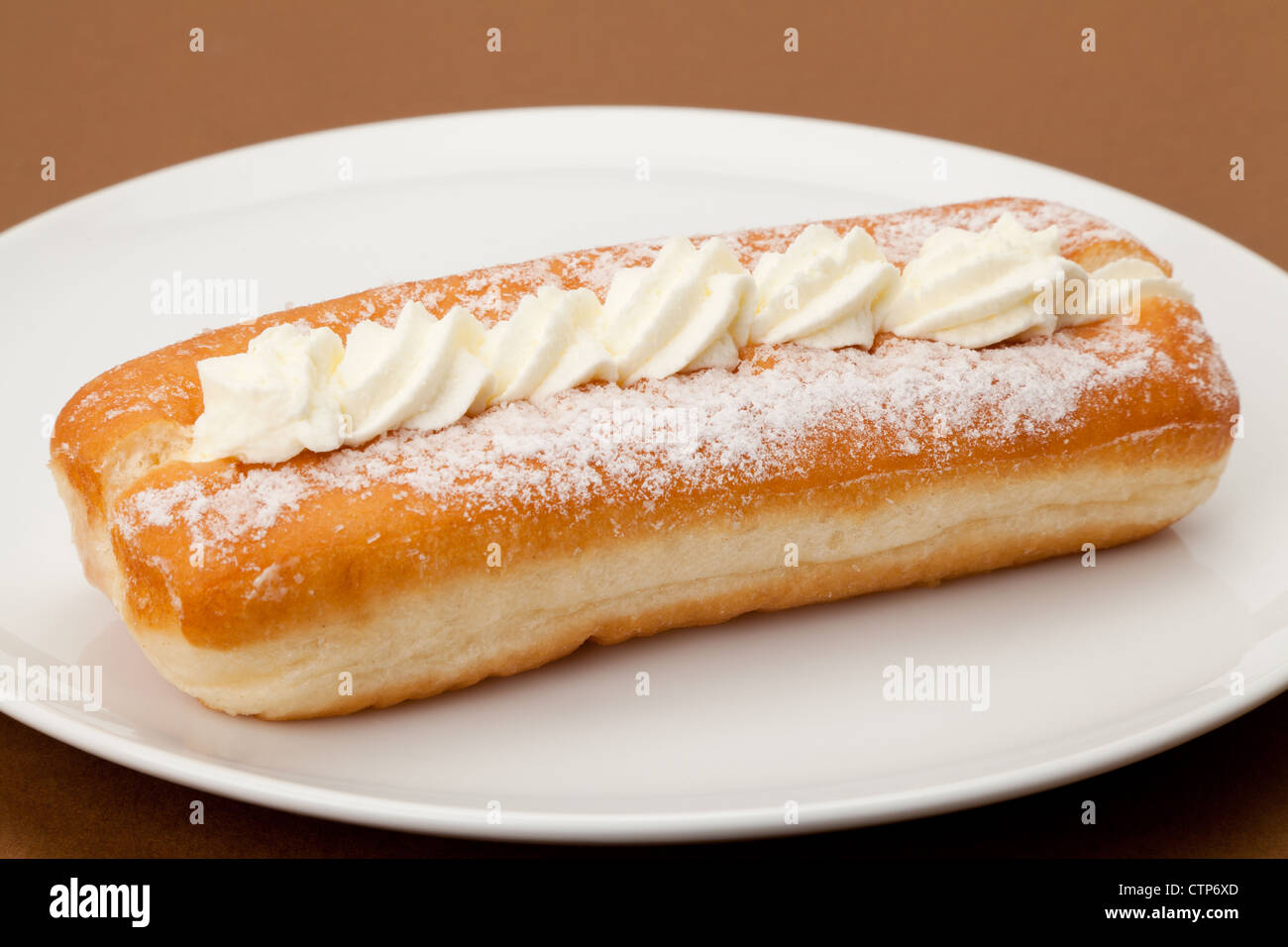 Fresh cream doughnut served on a white plate - studio shot with a plain ...