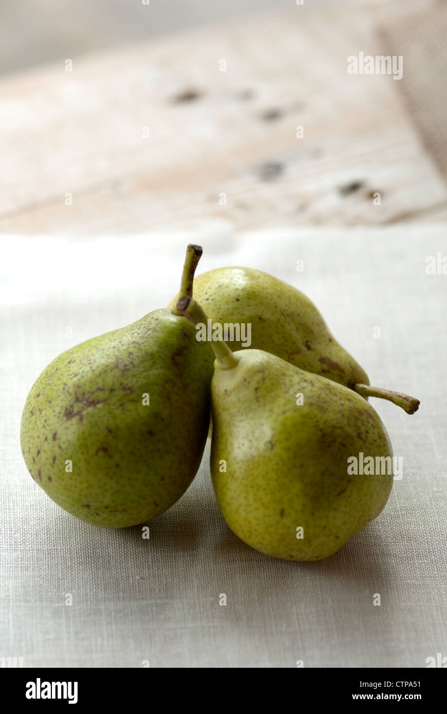 Three Guyot pears on a linen cloth against a light background Stock ...