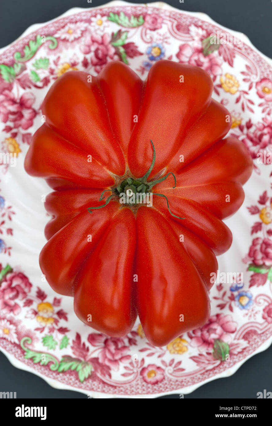 Giant Pink Beef Tomato (Zapotec Pleated) on plate Stock Photo - Alamy
