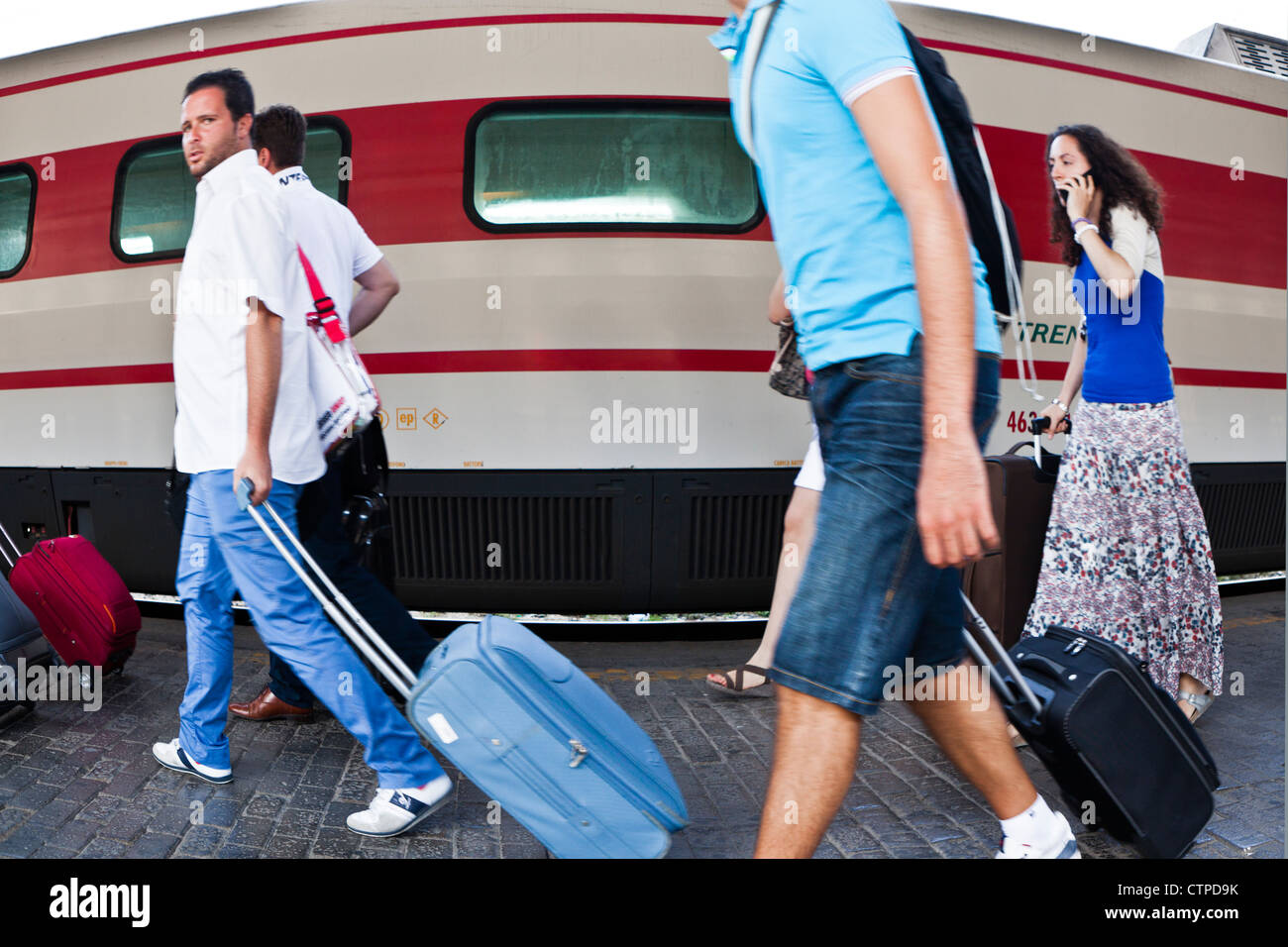 Rail passengers walking along platform with wheeled suitcases Stock ...