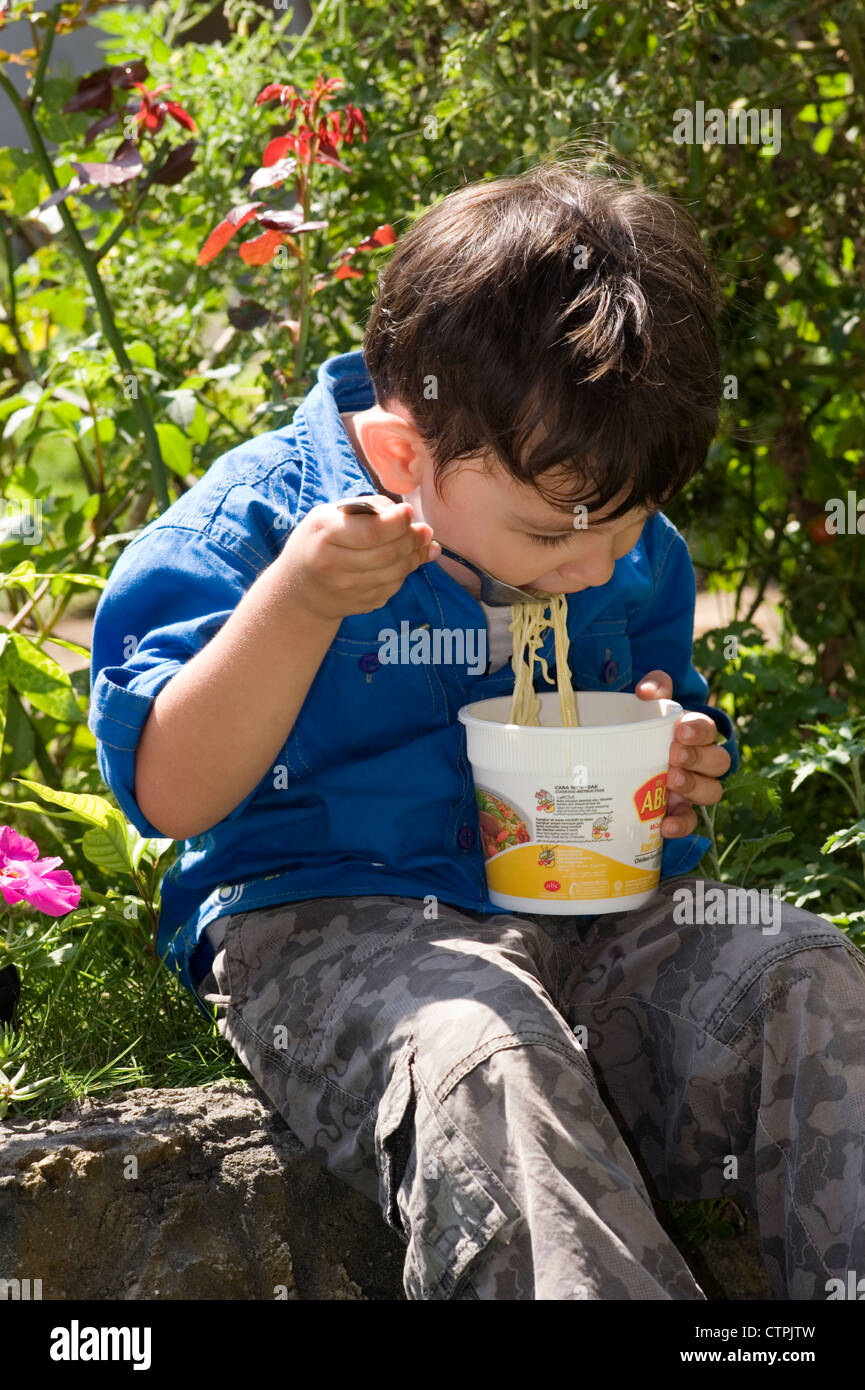 young boy enjoying meal of instant noodles Stock Photo - Alamy