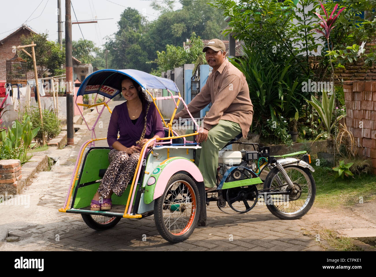 smiling local woman sitting in rare motorized becak in rural village ...