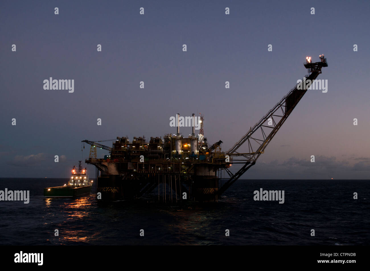 offshore oil rig PXIX at night, during tranfer operation with supply ...