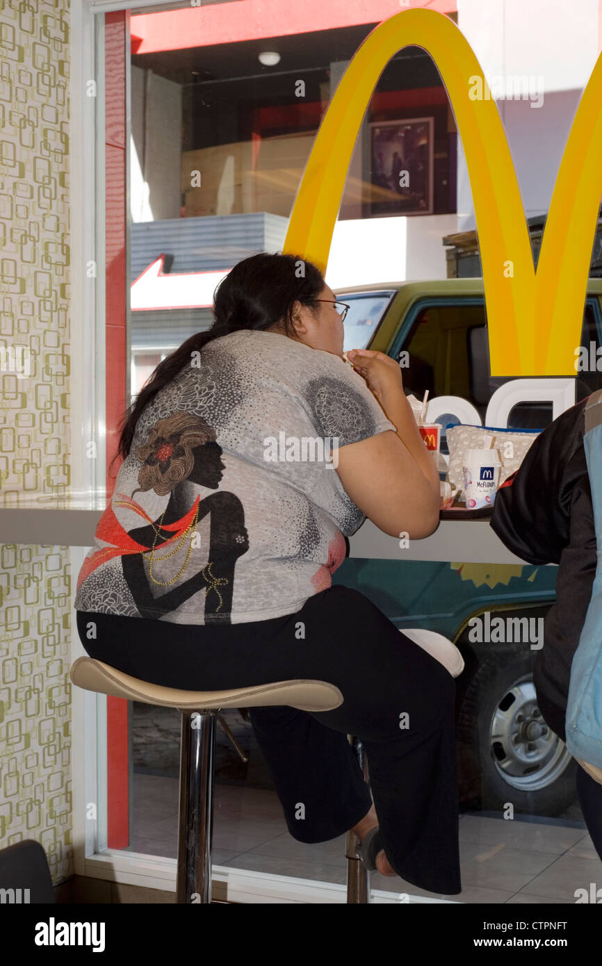 obese female eating fast food in restaurant indonesia Stock Photo - Alamy