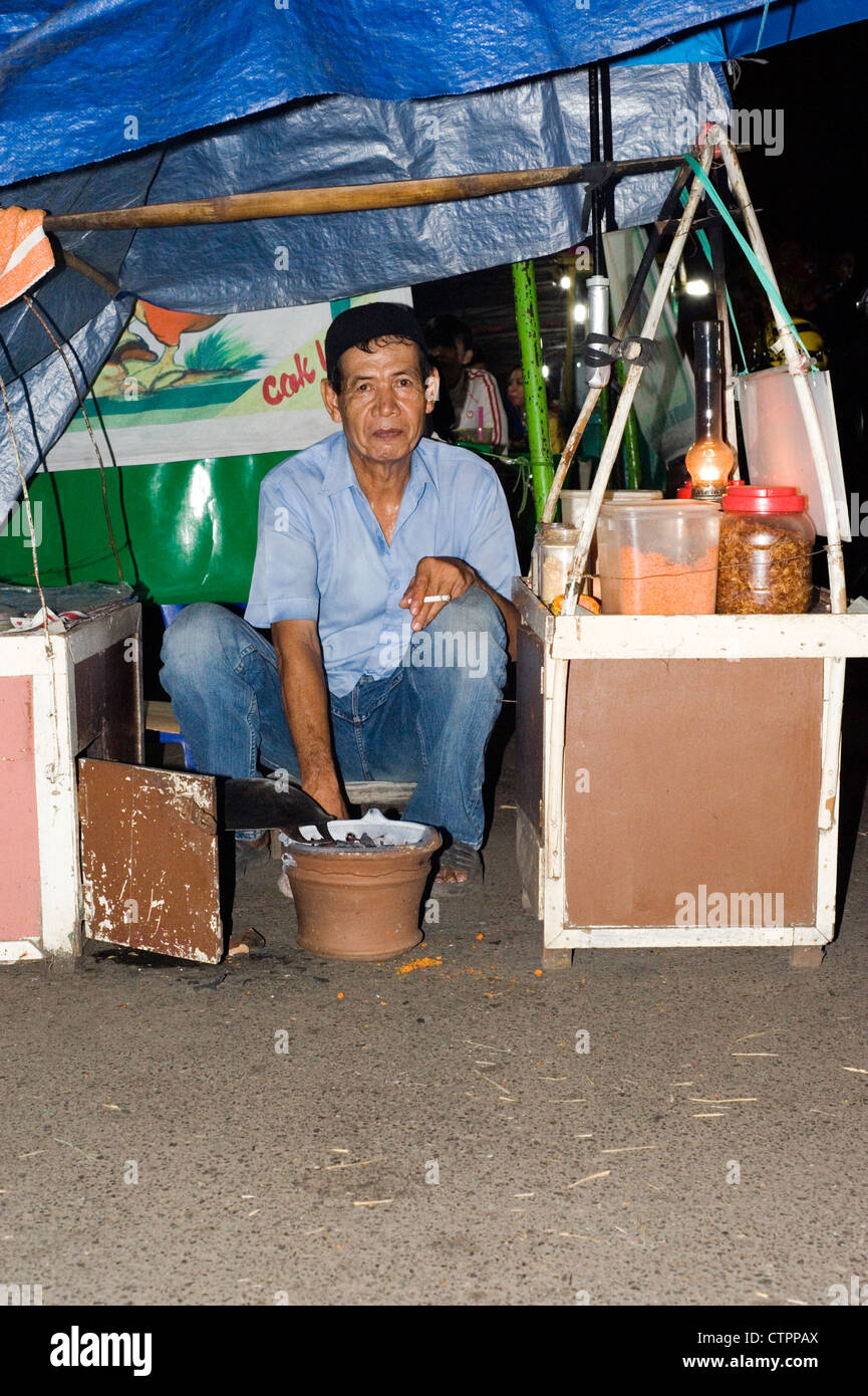 local man with his charcoal brazier for cooking food at a small local ...