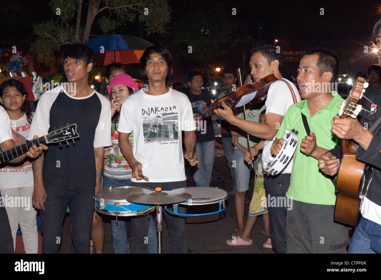 onlookers form an audience for a group of young local musicians at the ...