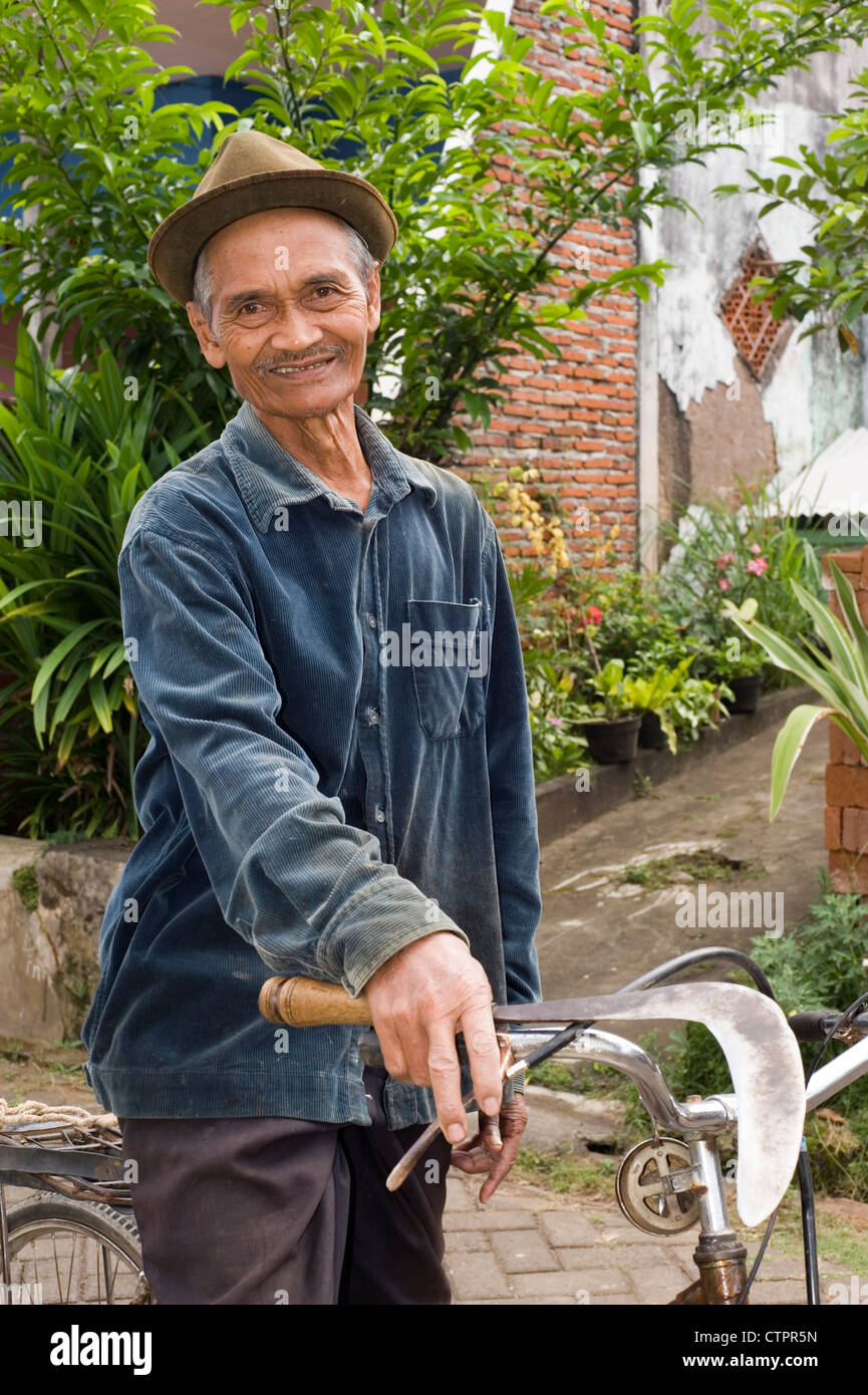 local villager in rural village street with scythe on his bicycle Stock ...