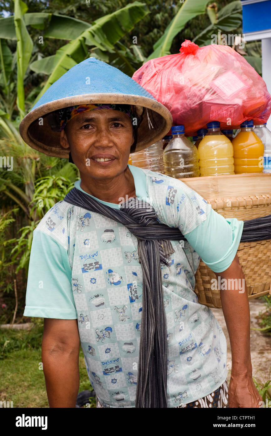 local female villager in rural village street with basket of local ...