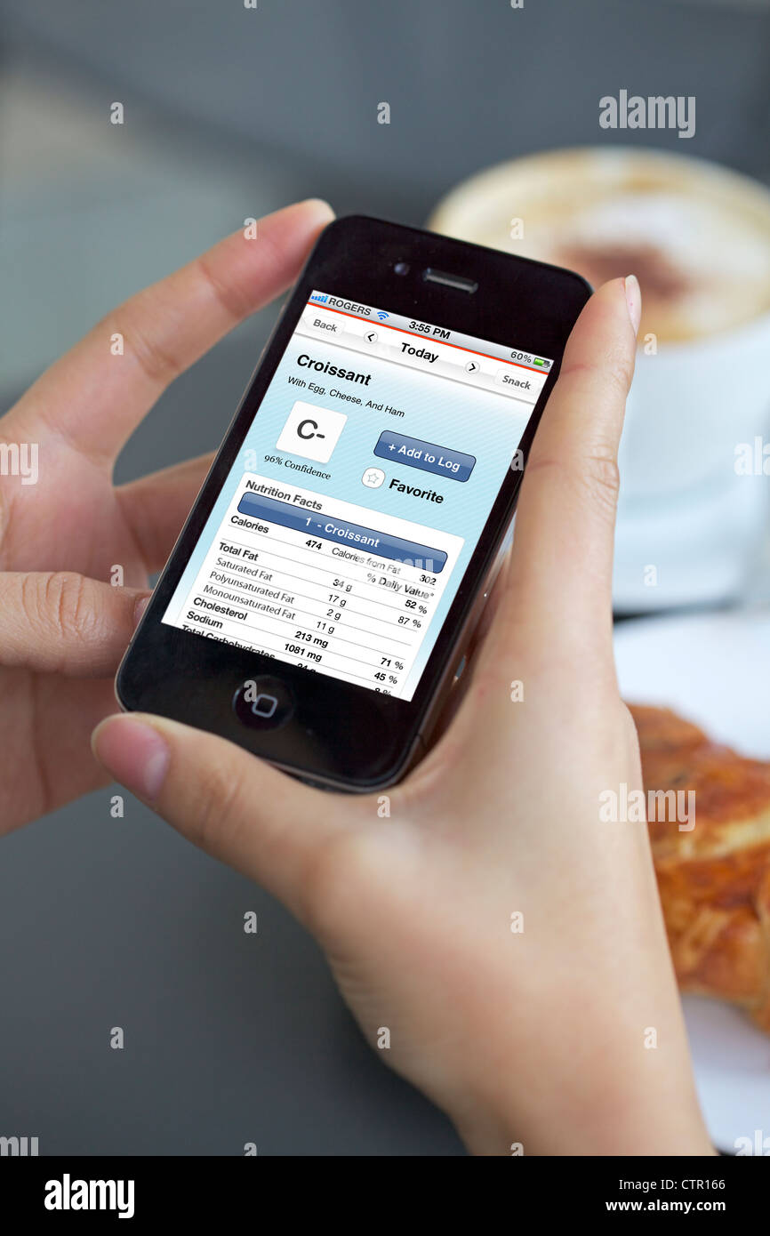 Health conscious female checking food calorie using calorie counter app ...