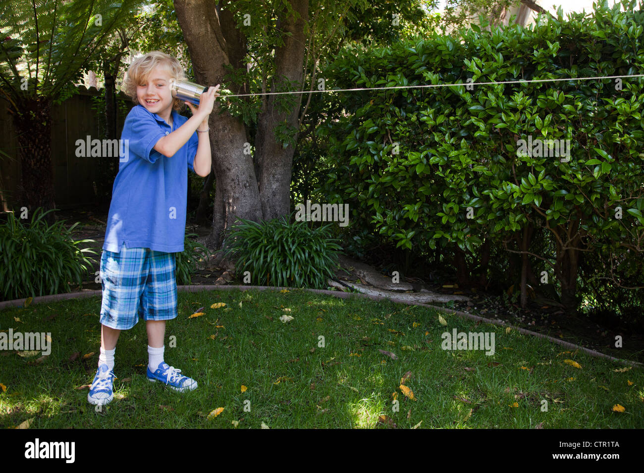 Boy holding a can and string, listening in Stock Photo - Alamy