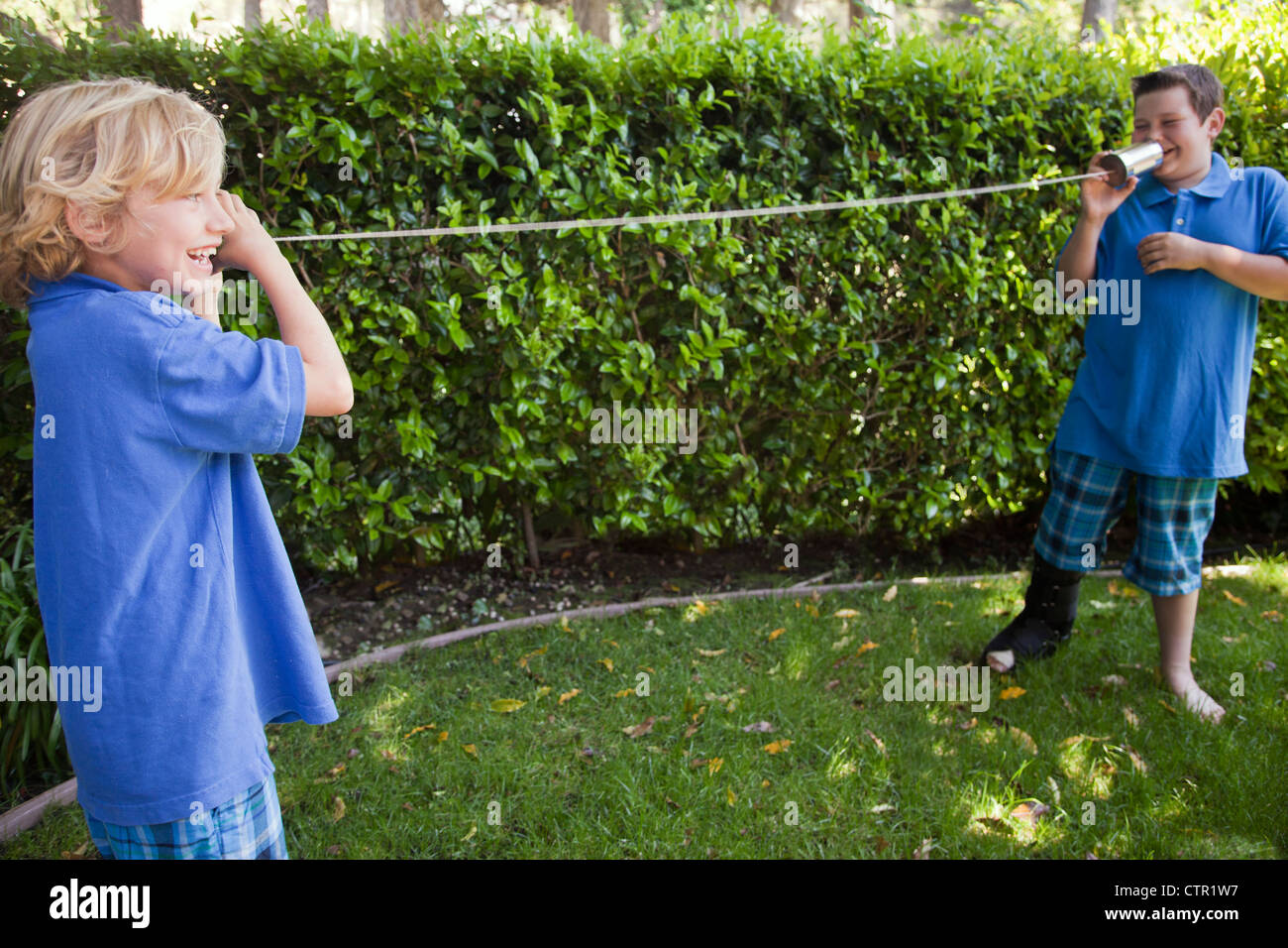 Two brothers talking on a can and string telephone Stock Photo - Alamy