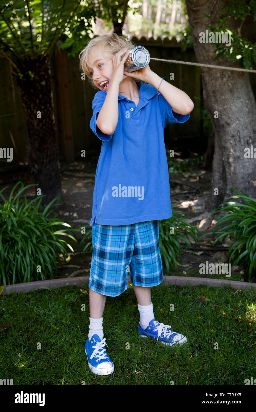 Boy holding a can and string, listening in Stock Photo - Alamy