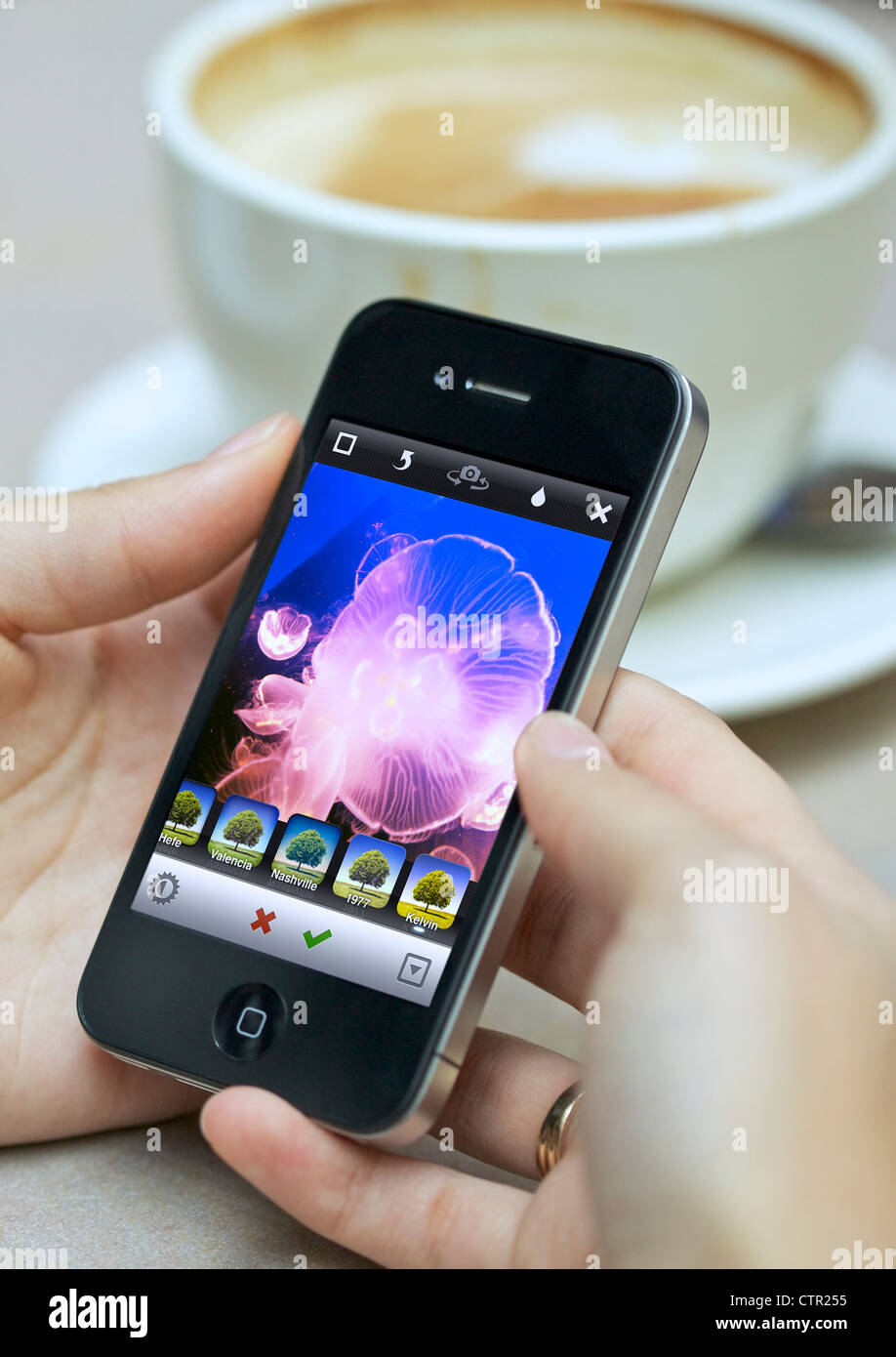 Close up picture of woman handholding an iphone using Instagram camera ...