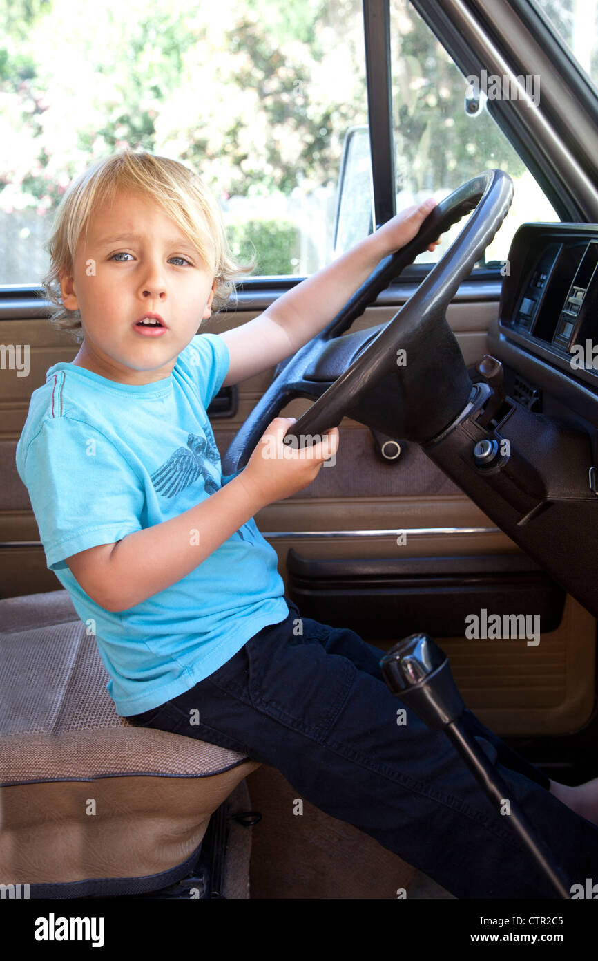 A little boy is behind a steering wheel pretending to drive Stock Photo ...