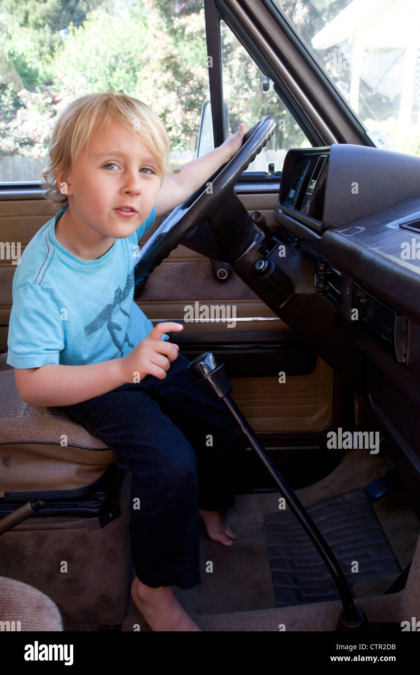 A little boy is behind a steering wheel pretending to drive Stock Photo ...