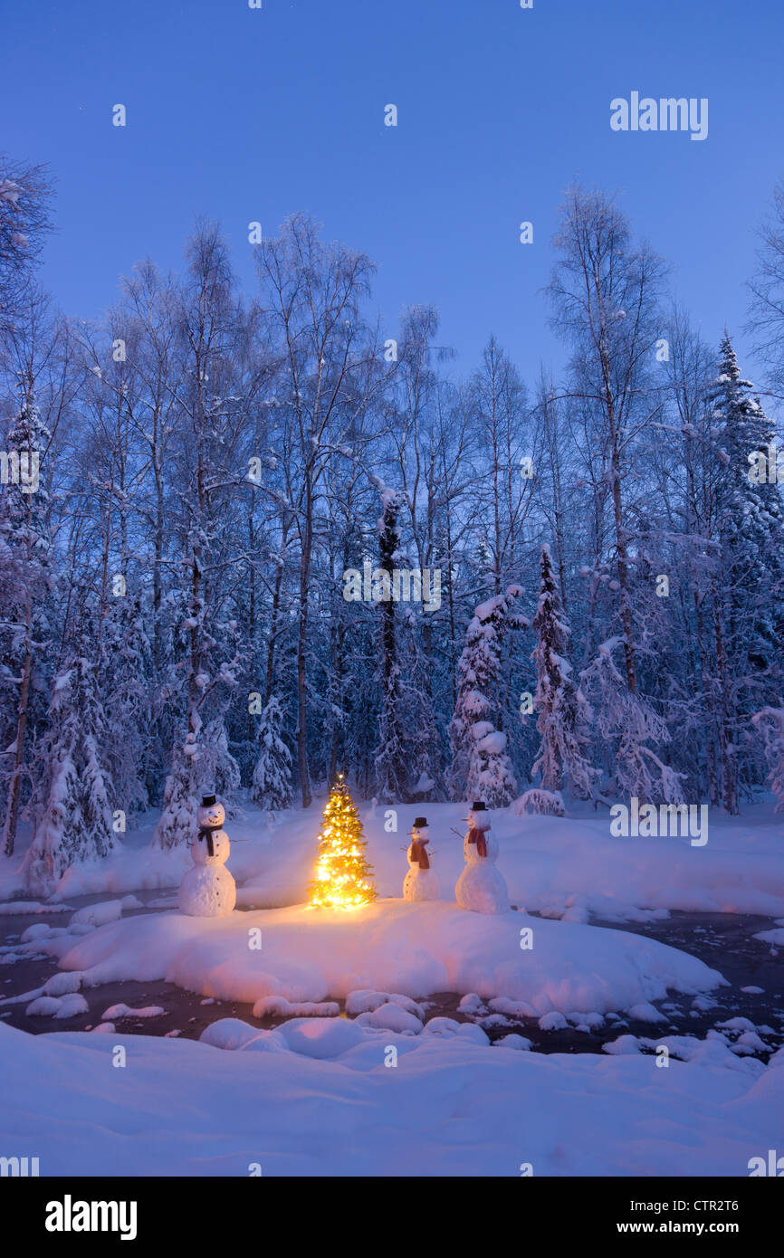 Snowman family standing next Christmas tree on snow covered island in ...