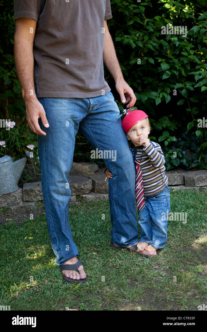 A little boy is hugging his father's pant leg Stock Photo - Alamy