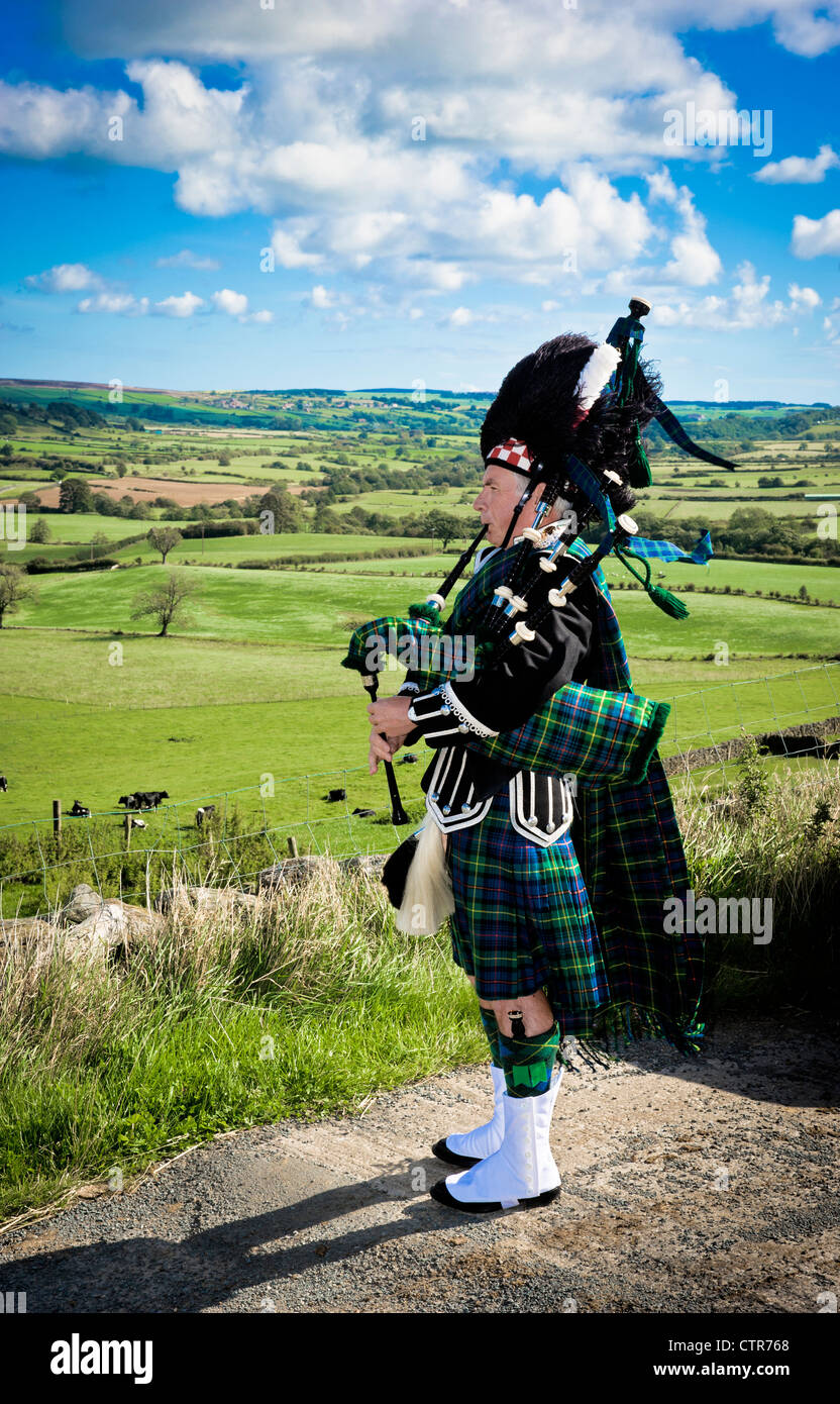 Caucasian male playing bagpipes, dressed in military costume including ...