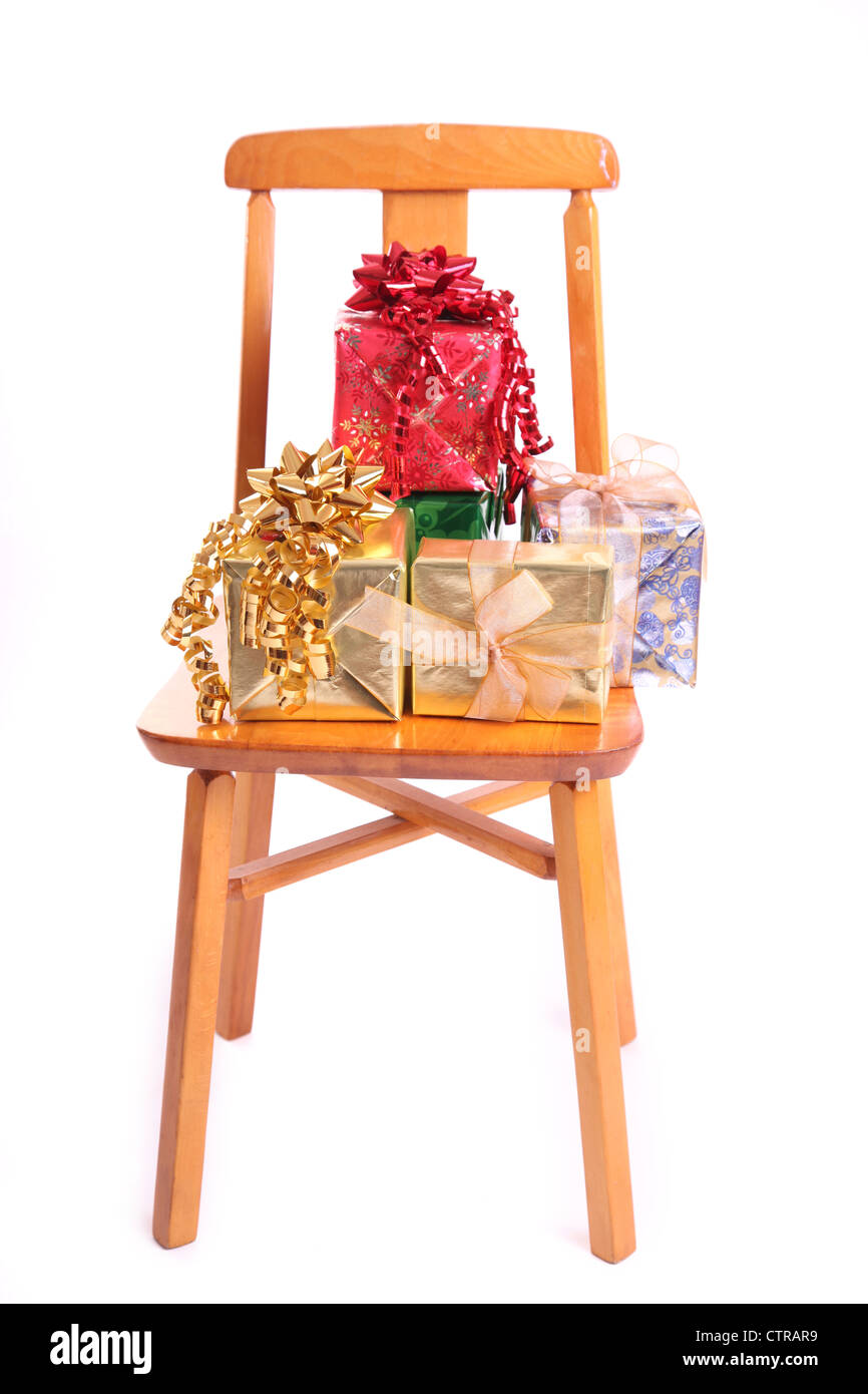 Foil wrapped Christmas gifts stacked on a child's wooden chair Stock ...
