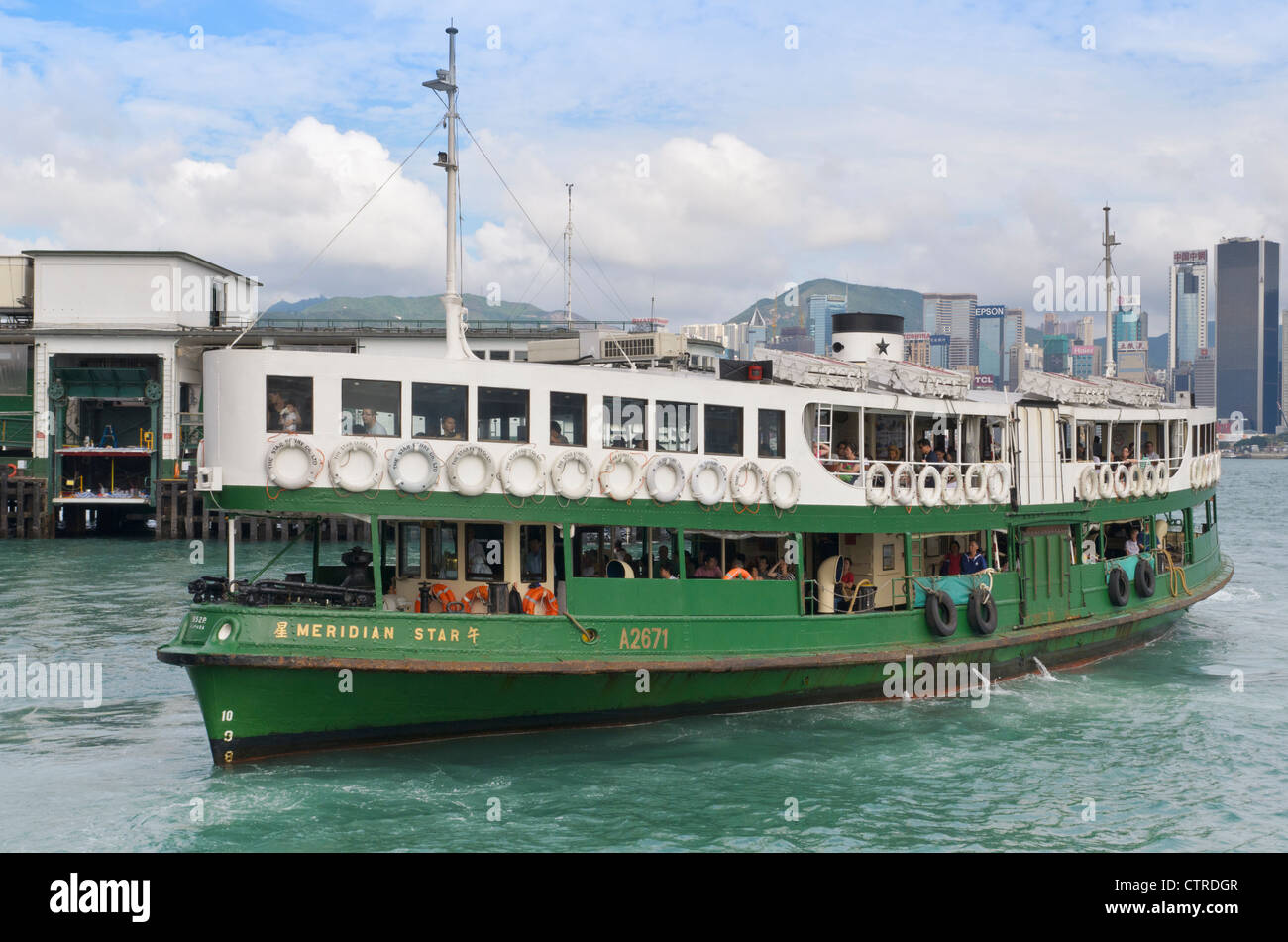 A traditional green and white Star Ferry carrying passengers in ...