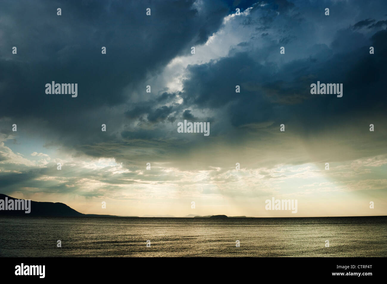 Sunset light beams stream through storm clouds over Orcas Island in the ...