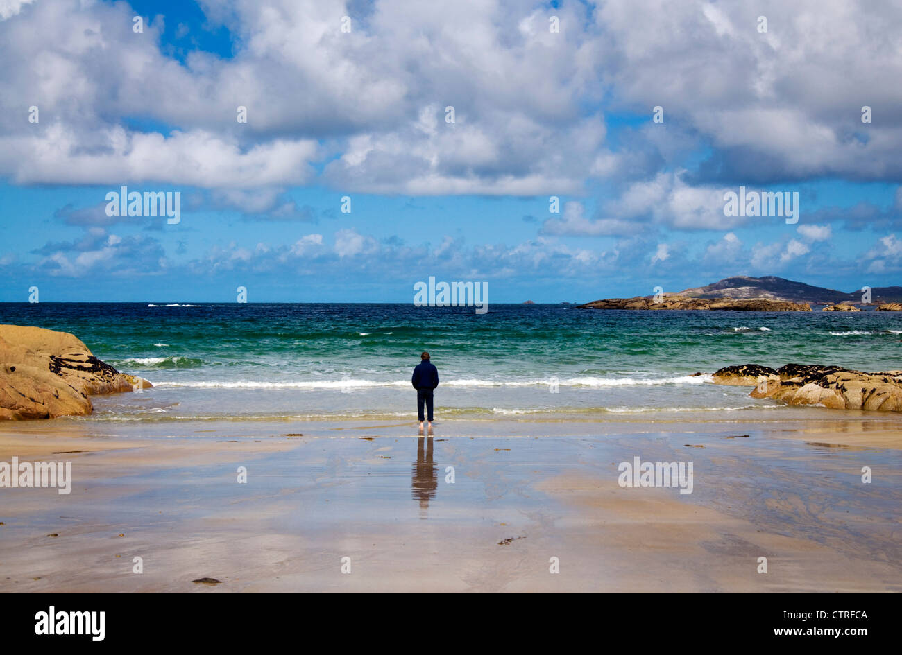 Man looking out to ocean from beach Stock Photo - Alamy
