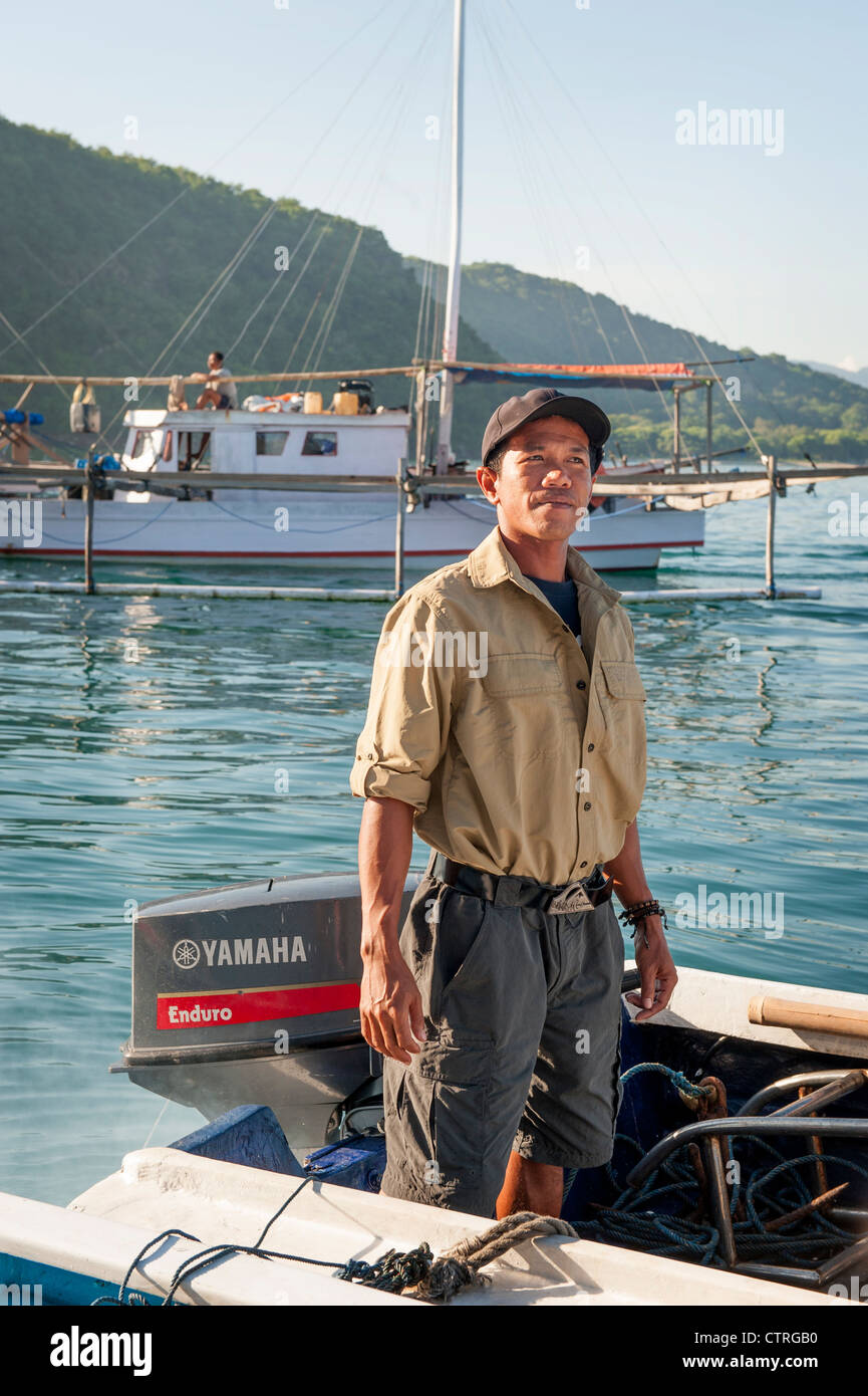 A crew member from the Ombak Putih, a schooner sailboat, ferries ...