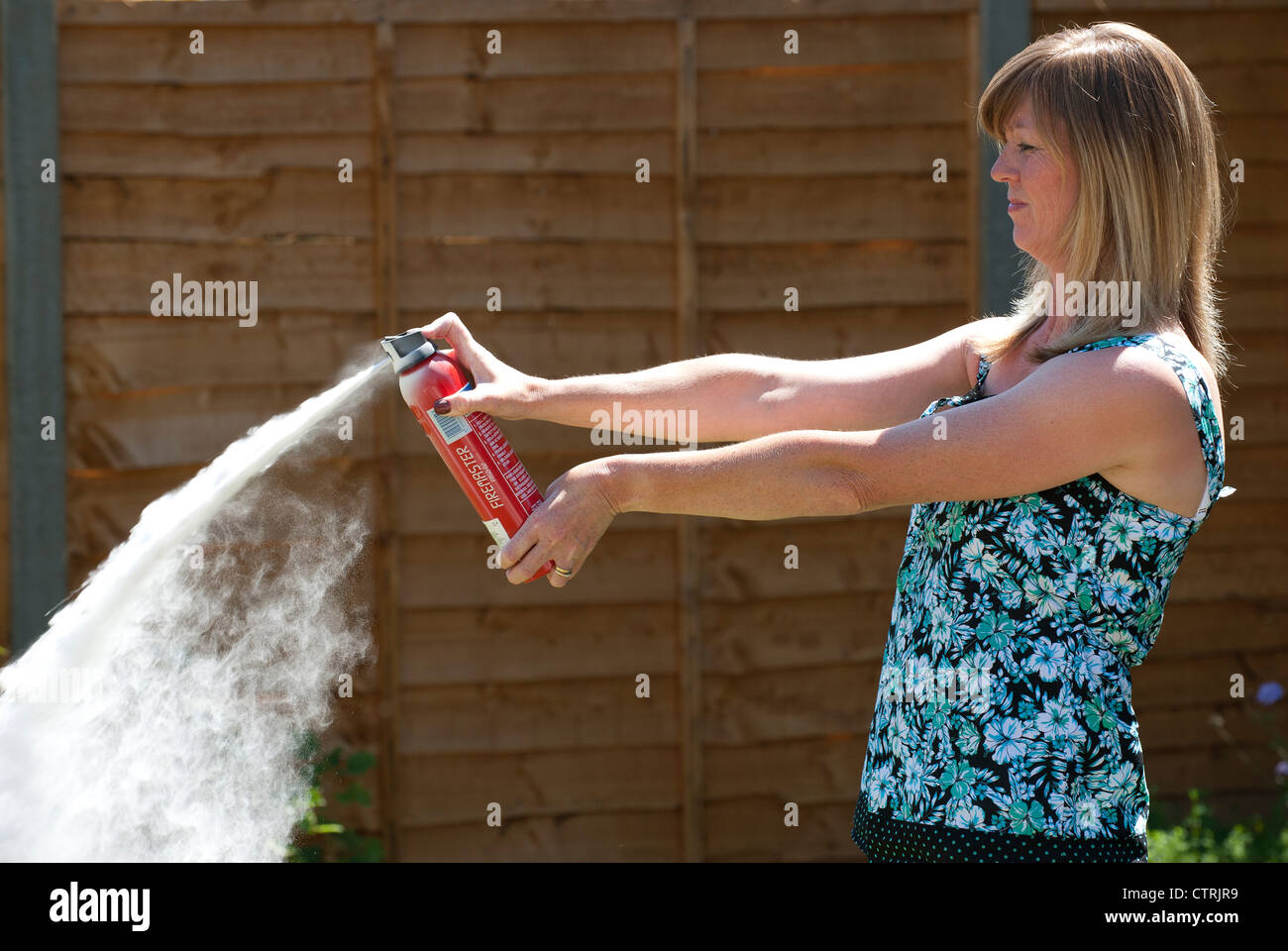 Woman using a dry powder fire extinguisher Stock Photo - Alamy
