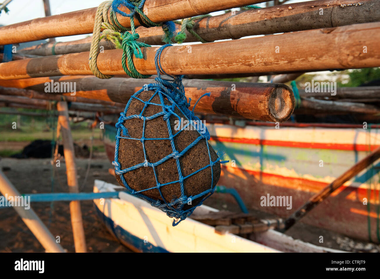 Traditional Balinese fishing boat with a rock used as an anchor. The ...