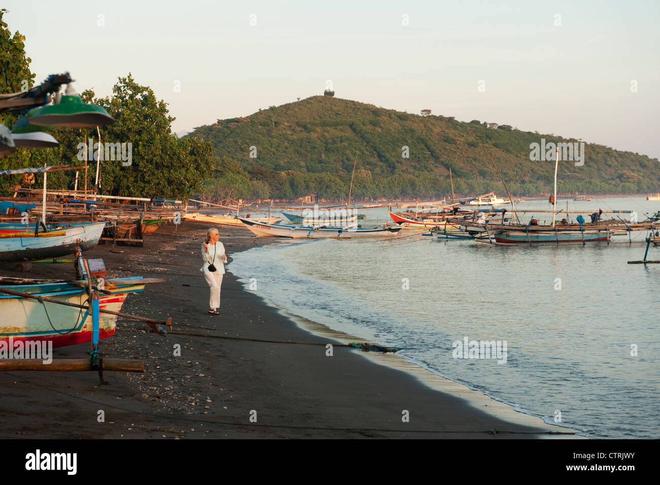 Traditional Balinese fishing boats line the beach waiting to go fishing ...