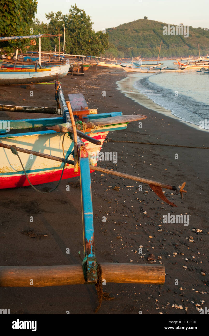 Traditional Balinese fishing boats line the beach waiting to go fishing ...