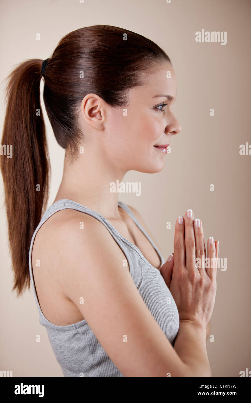 A young woman practicing yoga, hands in prayer position Stock Photo - Alamy