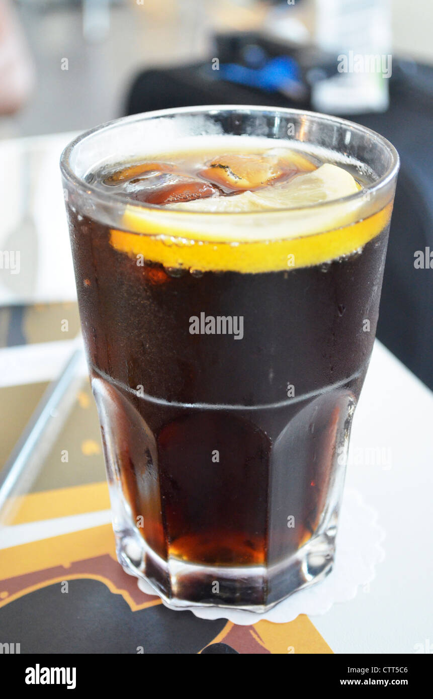 A pint glass filled with cola, ice and lemon Stock Photo - Alamy