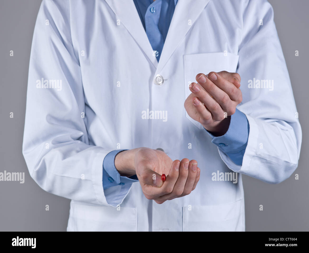 Pharmacist holding handful of colorful tablets in lab coat Stock Photo ...