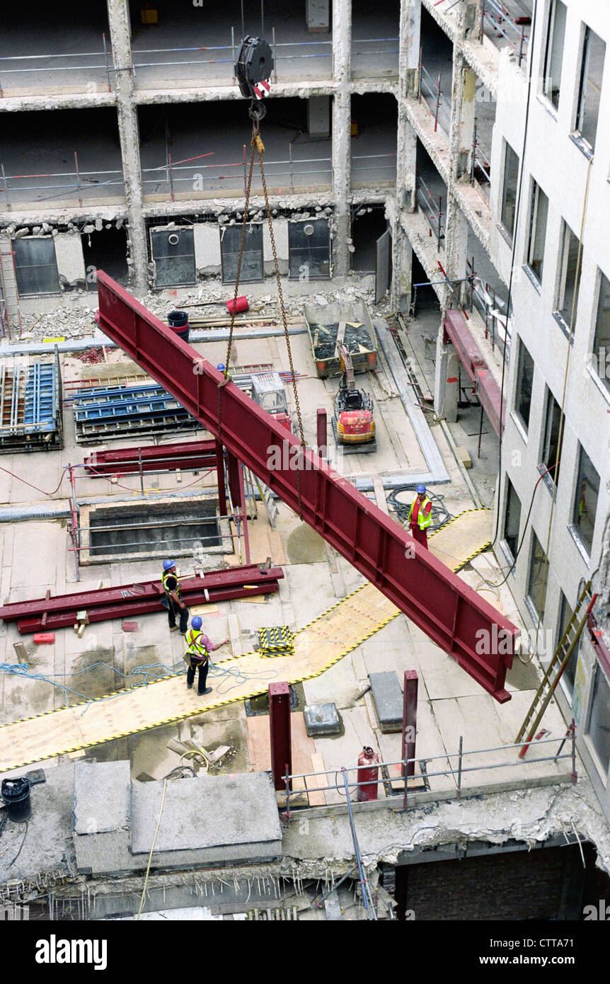 Overview of construction site showing a tower crane lifting a steel ...
